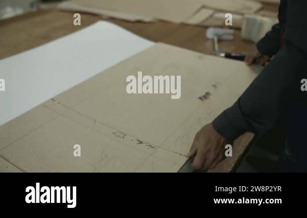 Man takes prepared cardboard and encircles it on paralon by black ...