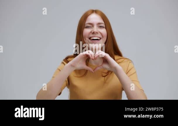 A young girl with a wide charming smile makes the fingers of mercy and ...