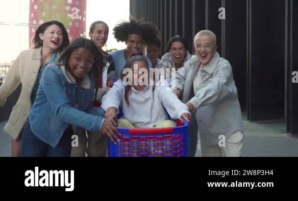Shopping cart race young multiethnic friends pushing shopping trolley ...