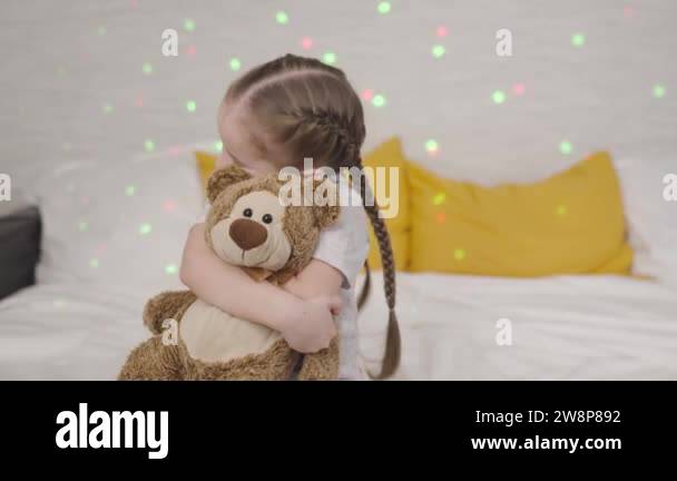 child hugs a teddy bear and smiles, a girl laughs while playing with ...