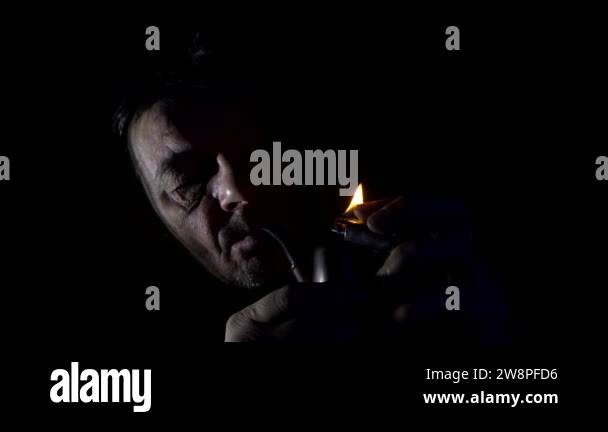 Man smoking pipe. A man lights a smoking pipe with a lighter Stock ...