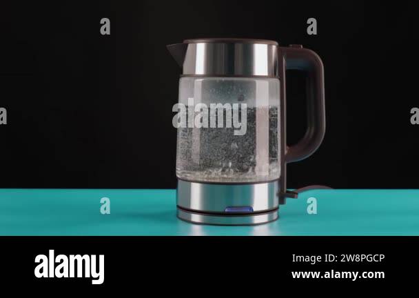 A modern glass electric kettle, on a blue table, black background ...