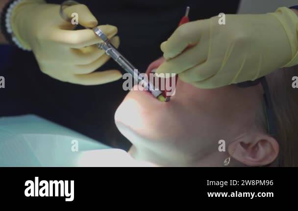real. dentist injects an anesthetic into patient before tooth ...