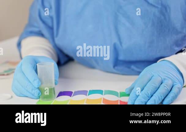 a laboratory assistant wearing a medical suit and gloves checks a ...