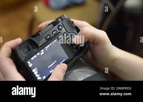 She sets up the camera before shooting. Man turns the wheels of the ...