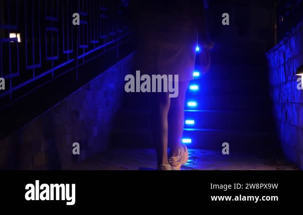 illuminated stair steps. close-up. silhouette of female legs, in ...