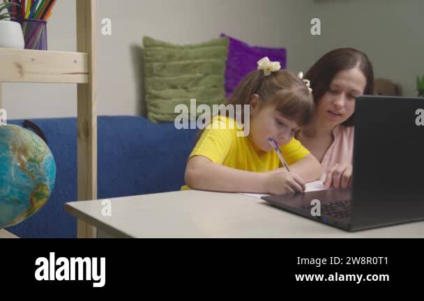 little child writes homework with a pen in a notebook, a kid does ...