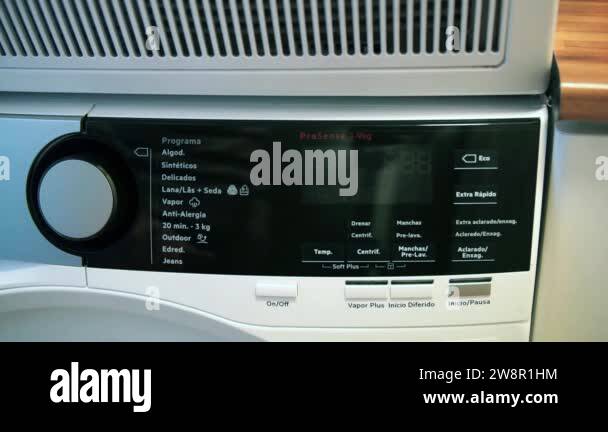 Close focus of washing machine panel, hand of person setting ECO ...