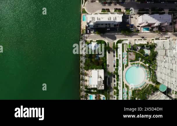 4k top view of the green water line streets, skyscrapers, swimming pools on the coast of ...