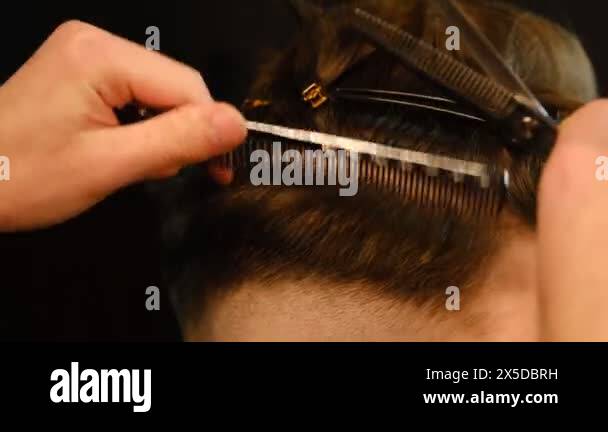 Close up Barber use Thinning scissors and metal comb on brown wavy hair ...