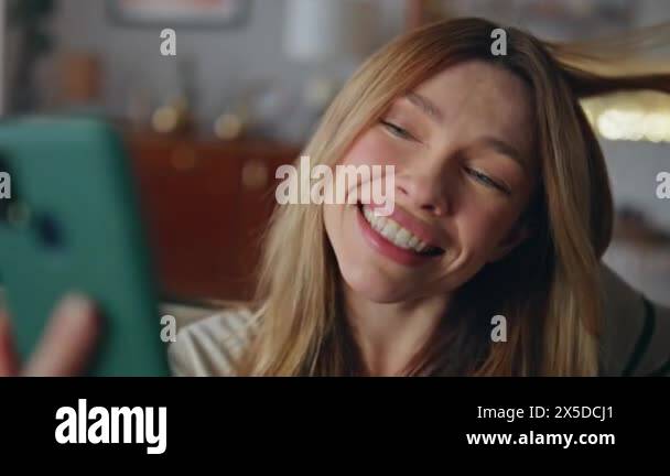 Girl video calling boyfriend holding mobile phone at home living room ...