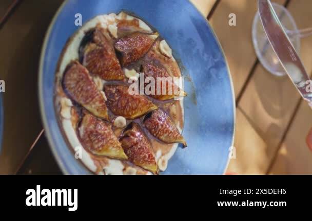 Lady hands taking hummus with figs from blue plate at cafe closeup ...