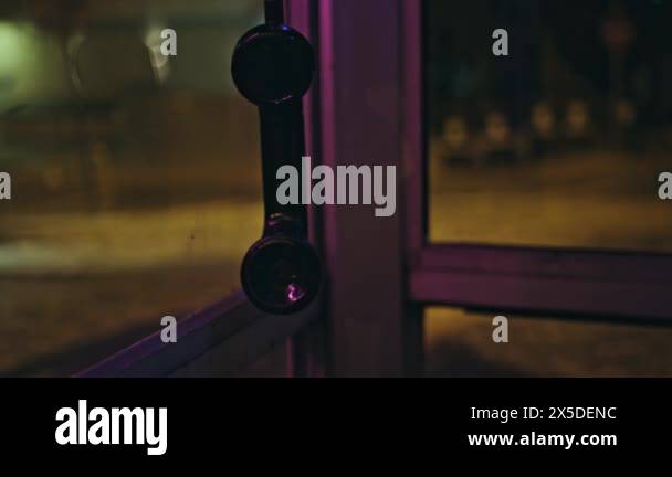 Black broken payphone landline handset swinging on wire in space with ...