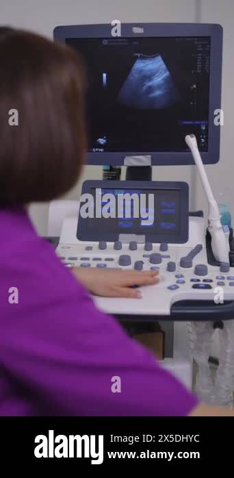 Vertical video. Female doctor performing an ultrasound scan. A woman ...