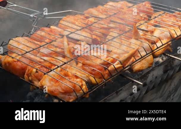 Delicious chicken frying on barbecue grill grate outdoor. Seasoning ...