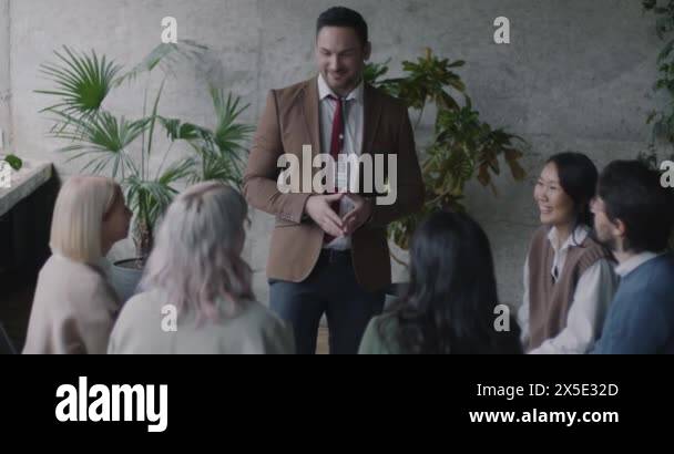 Confident businessman doing motivating team-building exercise with ...