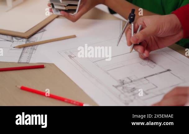 Slow motion interior designer drafting blueprint with customer ...