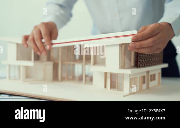 Professional male architect using ruler to measure house model length ...