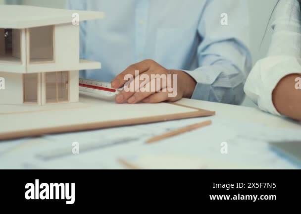 Professional male engineer measure house model by using ruler while ...