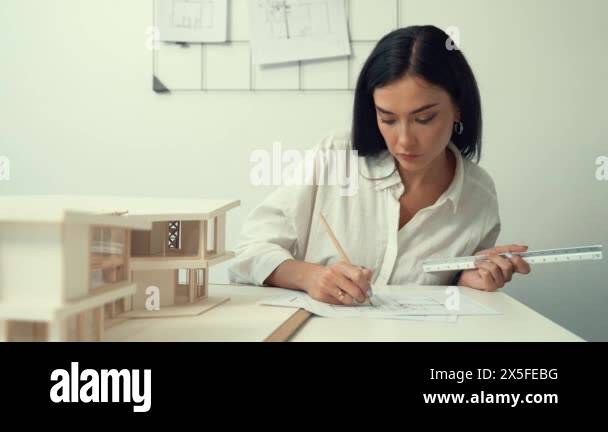 Closeup of beautiful young architect engineer focus on using pencil ...