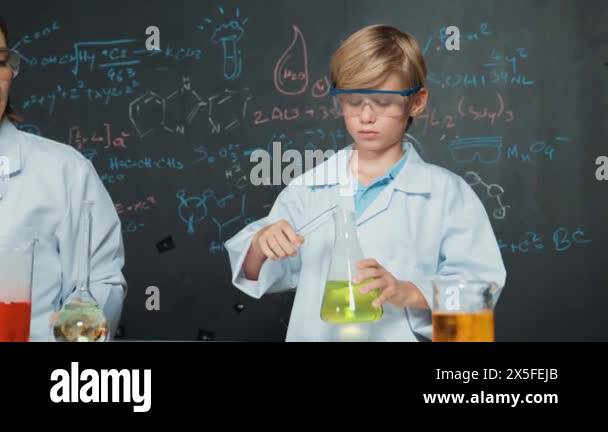Smart caucasian teacher mixing chemical liquid and inspect solution at ...