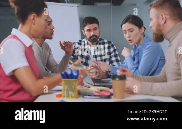 Manager looks on with disappointment as his team passionately debates ...