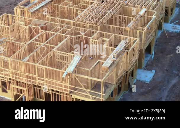 Wooden frame of apartment building ready for mounting roof beams under ...