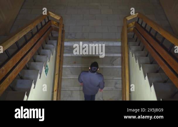 Top view of man walking up stairs of old building. Media. Young man ...