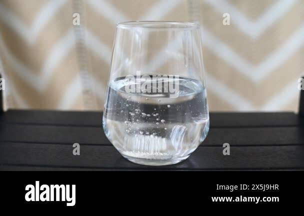 Close up sparkling water glass with dissolving effervescent vitamin ...