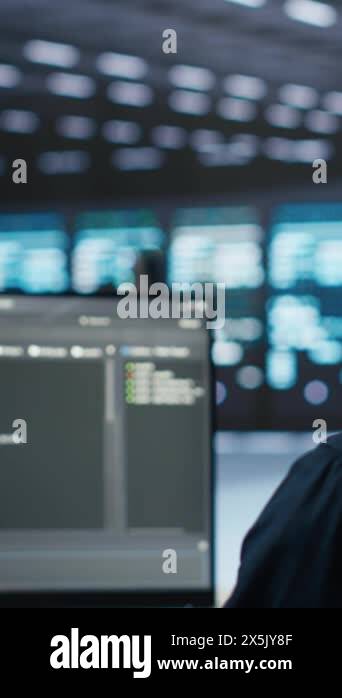 Vertical Video System Administrator Running Script On Computer Screen In High Tech Data Center 