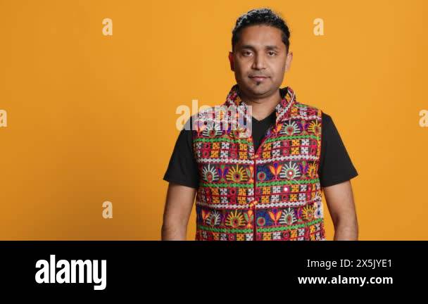 Portrait of jolly indian man with colorful garment smiling, looking ...