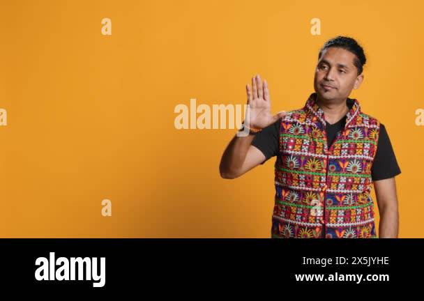 Indian man trying to stop chaotic fight using calming hand gesture to ...