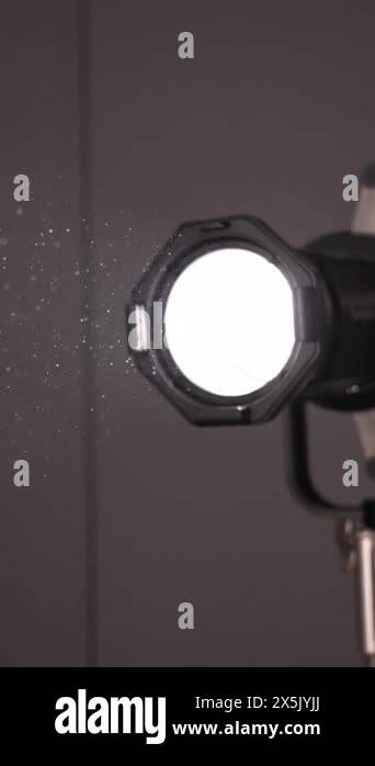 Beam of light from spotlight illuminates dark room. Dust particles ...