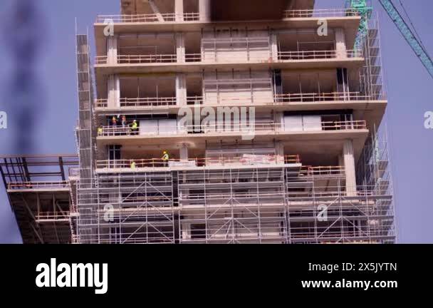 Workers sheathing walls of building facade cladding, walls in house ...