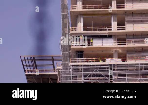 Workers sheathing walls of building facade cladding, walls in house ...