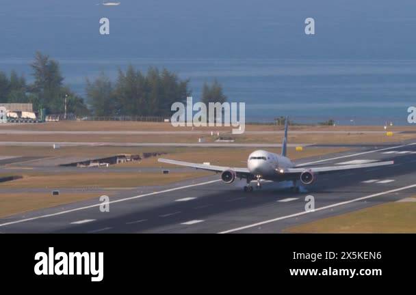 PHUKET, THAILAND - FEBRUARY 23, 2023: Airplane on the runway, next to ...