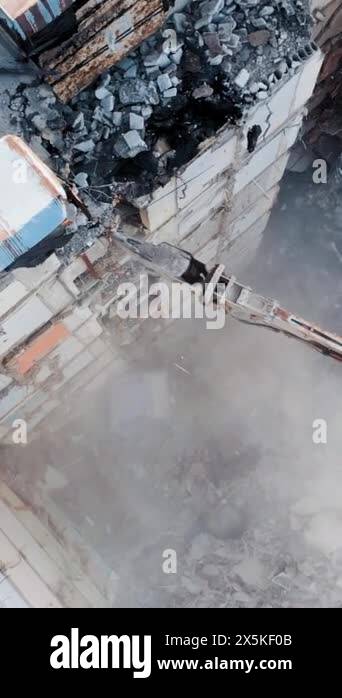 Dismantling of concrete structures with an excavator. Demolition of a ...