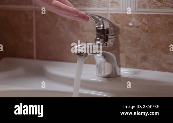 Water flows metallic faucet domestic bathroom stream liquid white sink ...