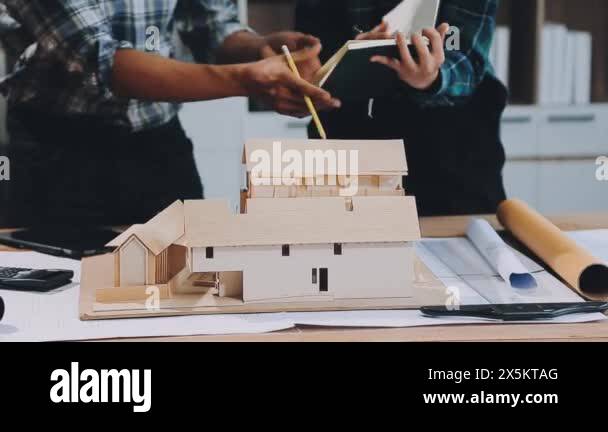 man engineer or engineer working with model of house and model house ...