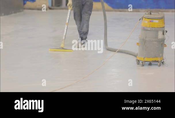 A builder cleans the construction site of dust using a construction ...