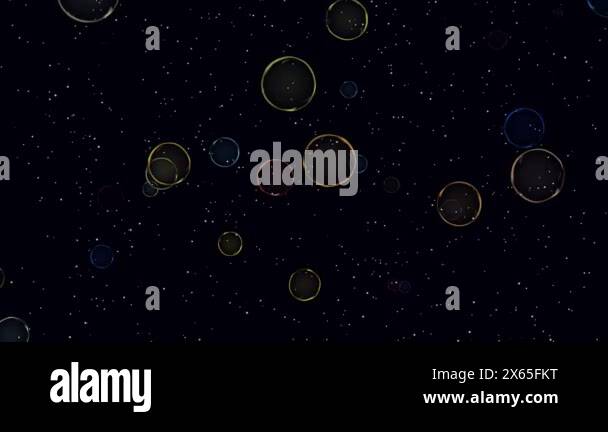 Colored balls float in space on a dark background with small particles ...