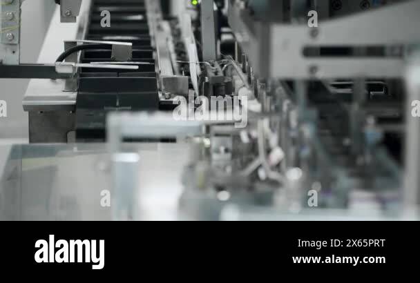 Robotic arm put medicine package on conveyor belt. Packaged goods at ...