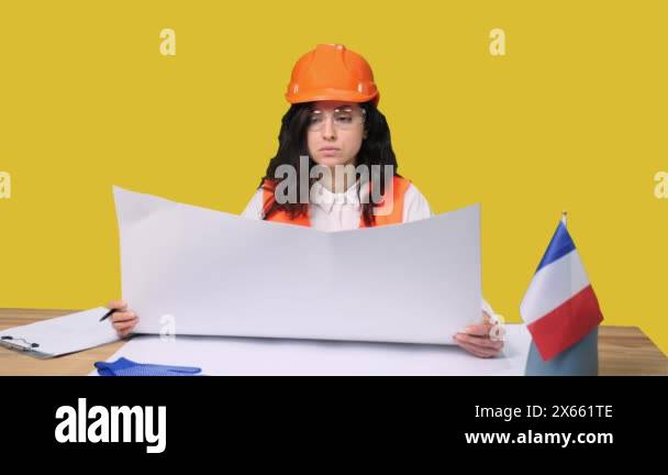 Young female engineer with safety helmet holding yellowprint and making ...
