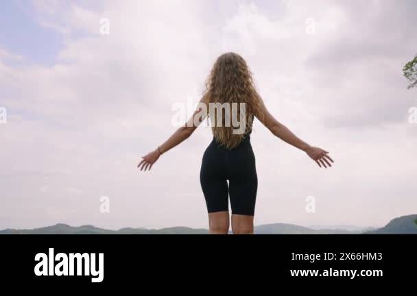 Curly-haired lady feels free, absorbs natural beauty, peaceful highland ...