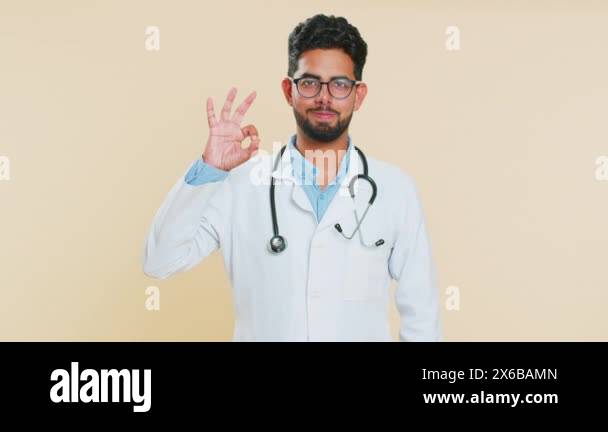 Okay. Happy Indian young doctor cardiologist man show ok gesture, like ...