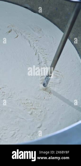 Slow motion of mixer in metal bowl for making cheese. Factory equipment ...