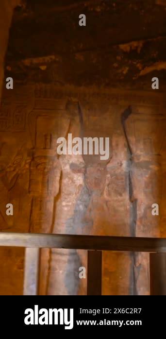 A young woman visiting the illuminated interior of the Abu Simbel ...