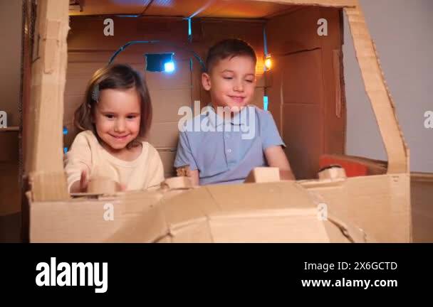 boy controls the space shuttle. Children play with a cardboard ...