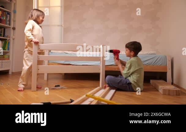 the boy assembles the bed himself in the childrens room. the boy ...