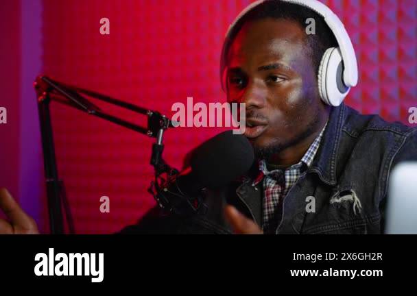 African american vlogger using microphone and headphones to record vlog ...